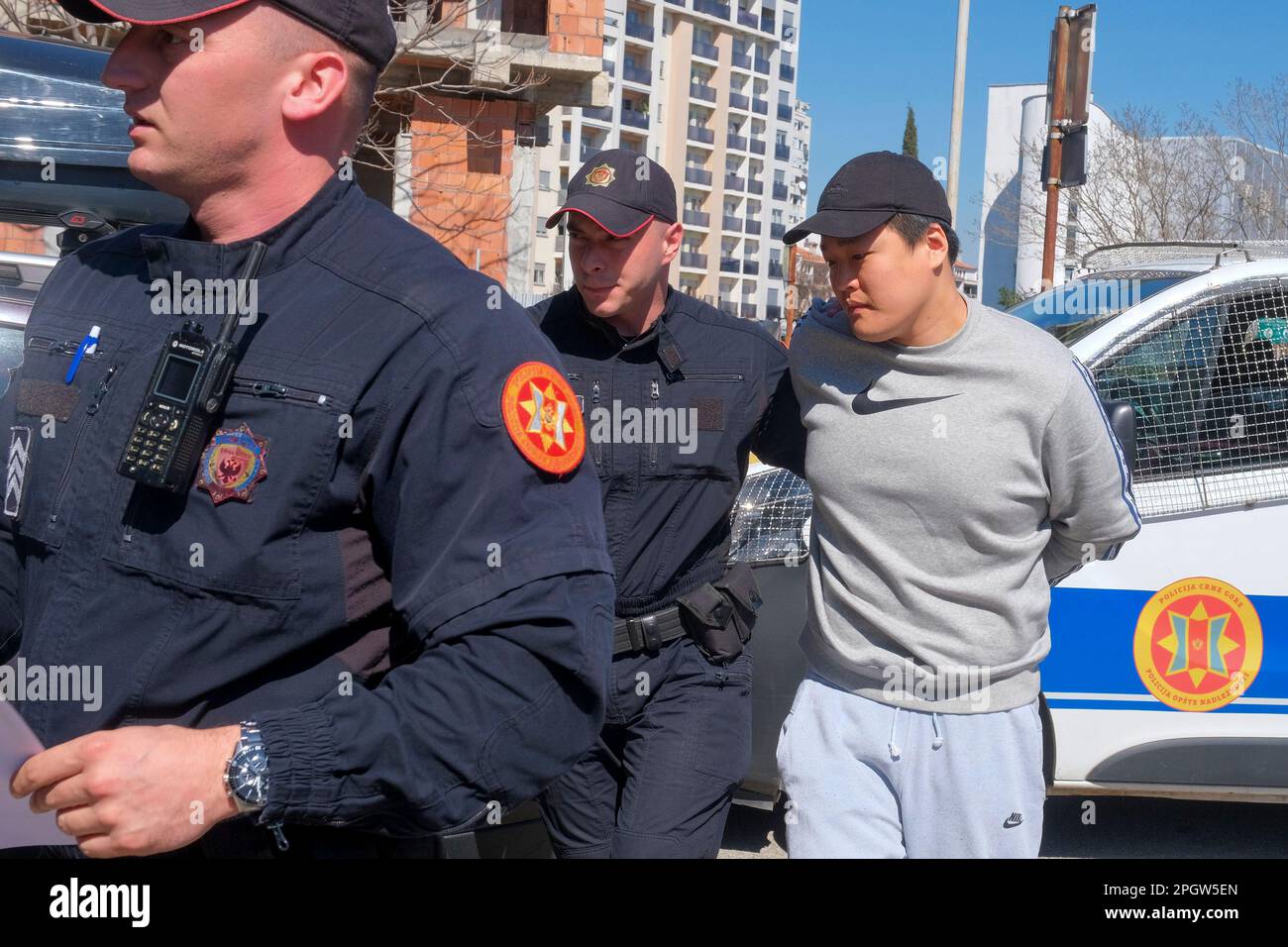 Montenegrin police officers escort an individual who is believed to be ...