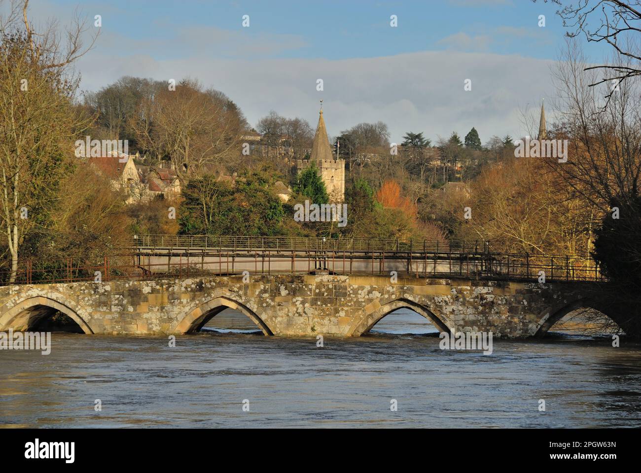 Swollen river Avon flowing beneath the 14th century packhorse bridge ...
