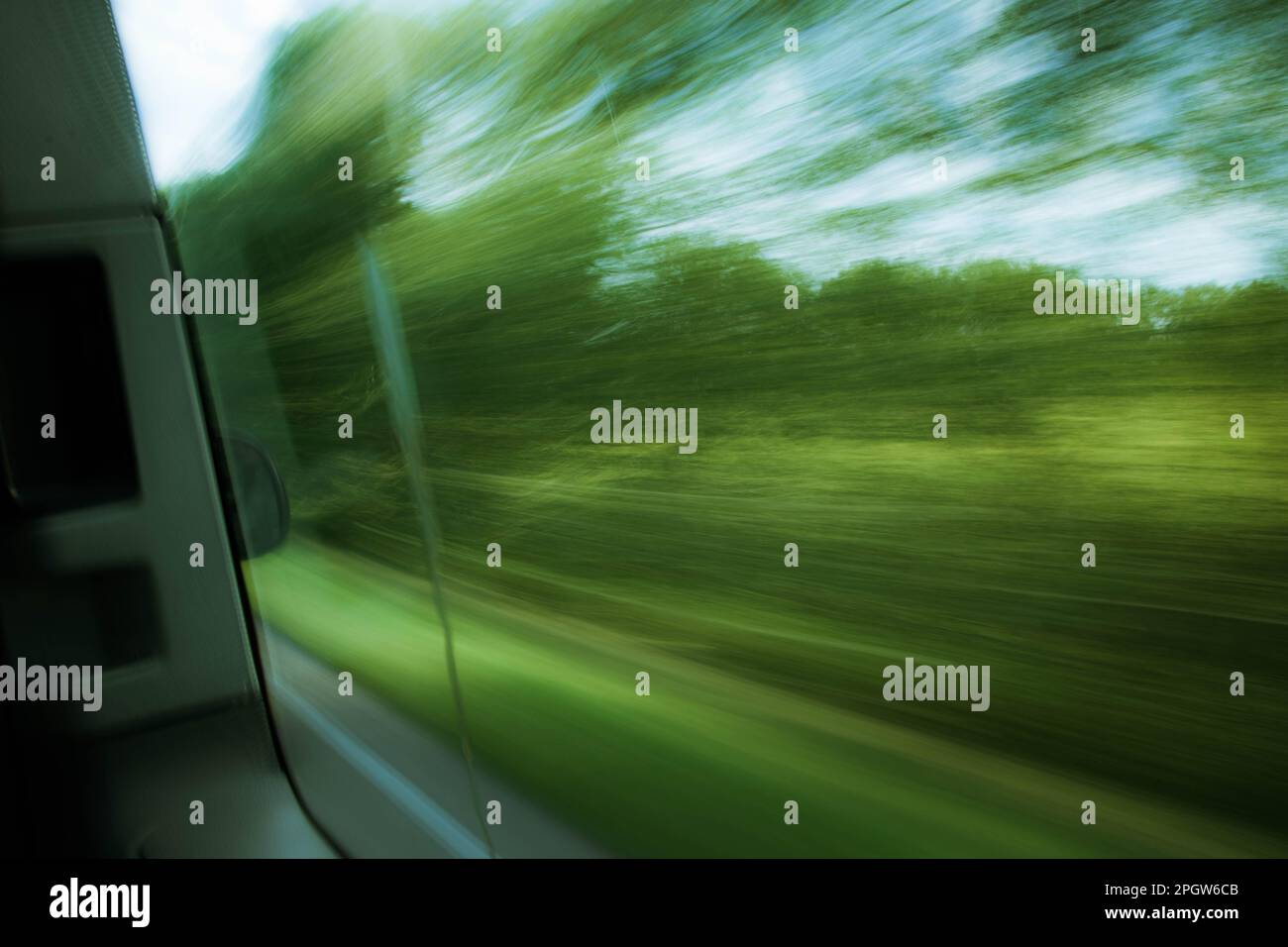 A scenic view of trees seen with a blur effect through the window of a ...