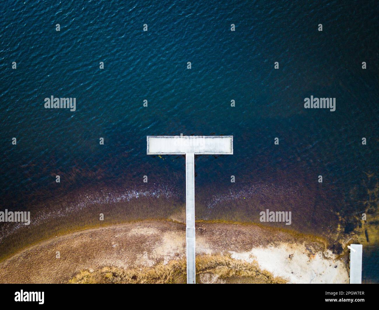 An aerial view of a beach showcasing its pristine shoreline and pier ...