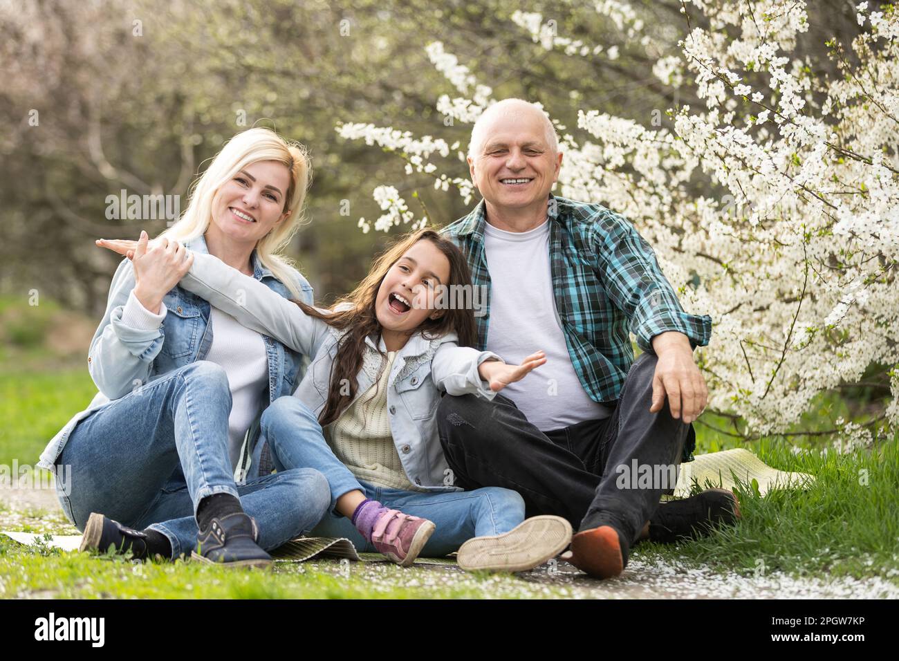 family having picnic in park, garden with flowering trees, spring Stock ...