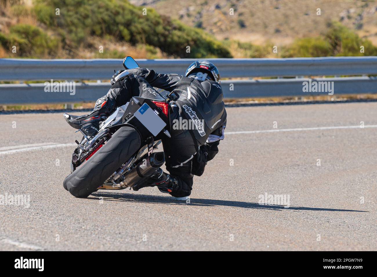 Rider on the asphalt with his bike leaning around a curve Stock Photo ...
