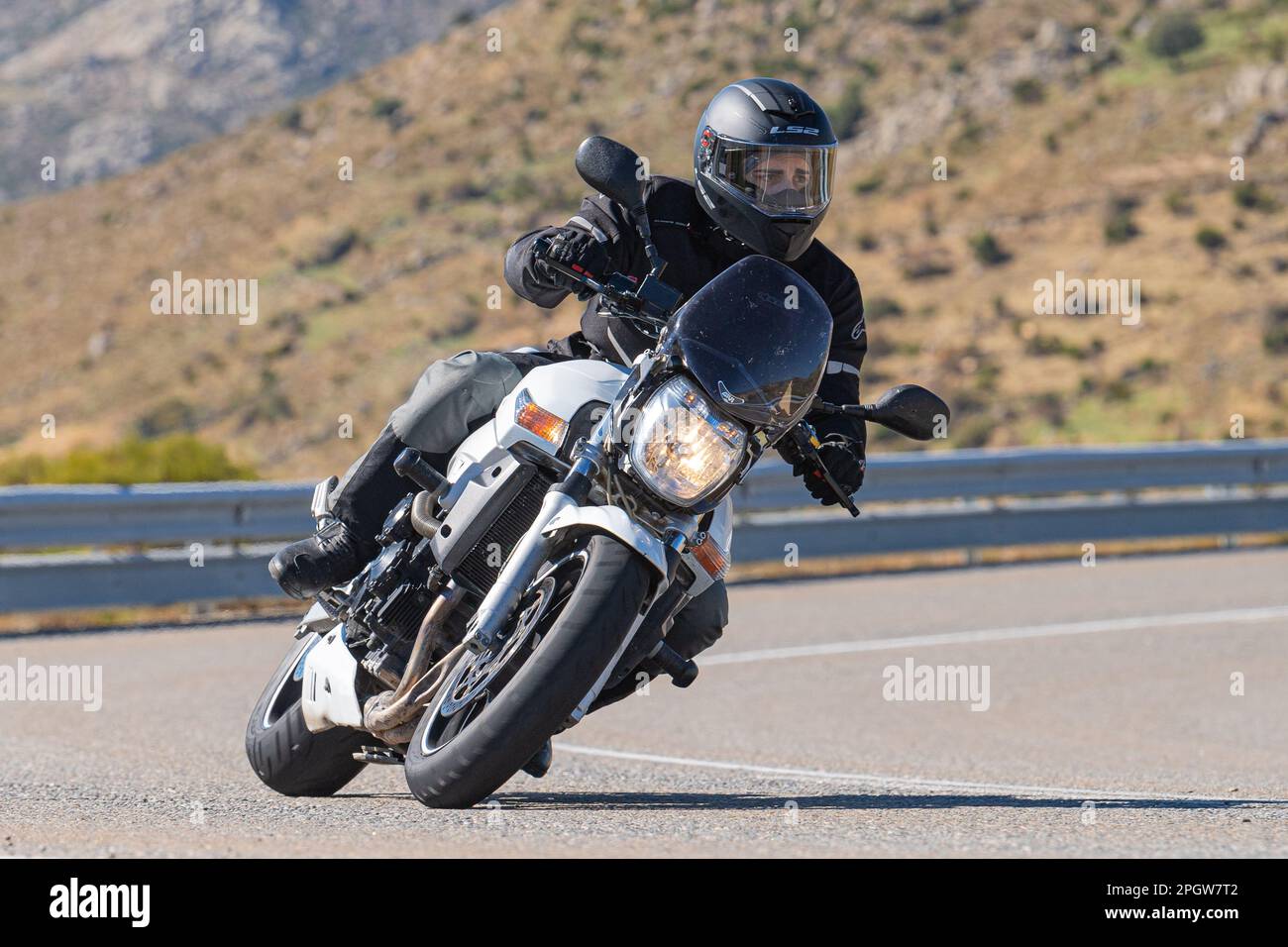 Rider on the asphalt with his bike leaning around a curve Stock Photo ...