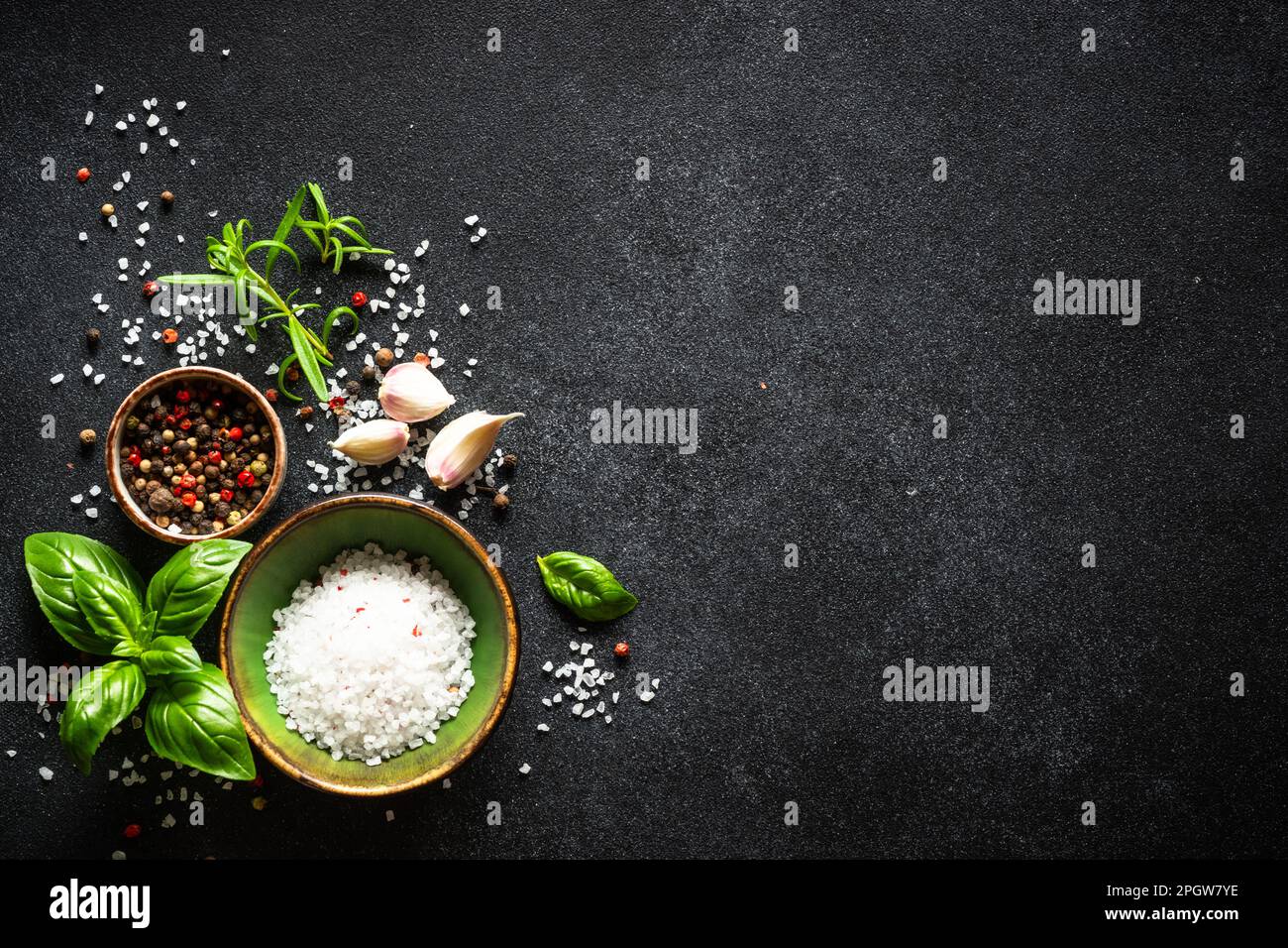 Food cooking background with spices and basil at black. Top view with ...