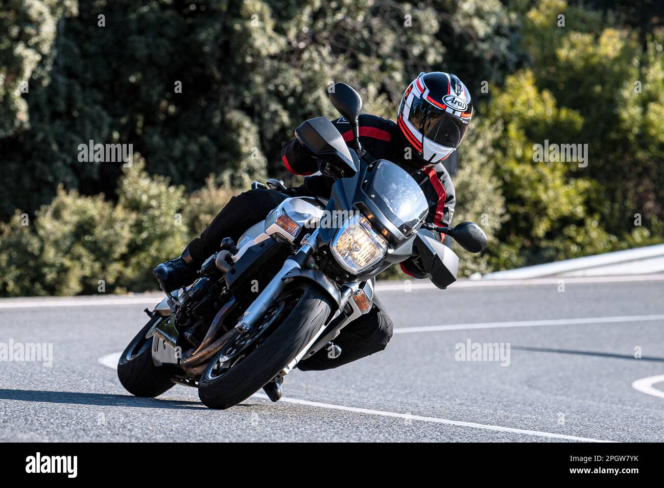 Rider on the asphalt with his bike leaning around a curve Stock Photo ...