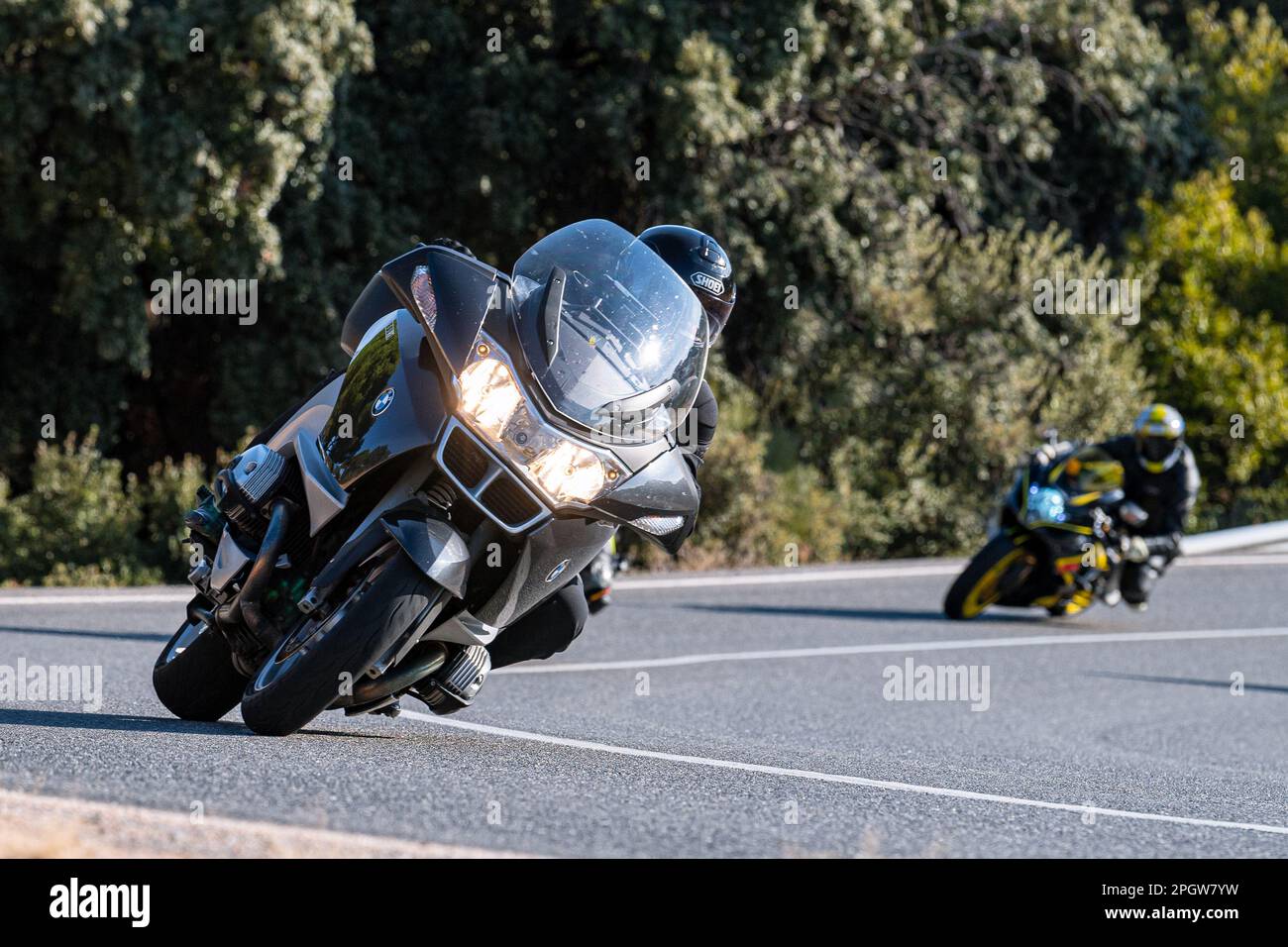 Rider on the asphalt with his bike leaning around a curve Stock Photo ...