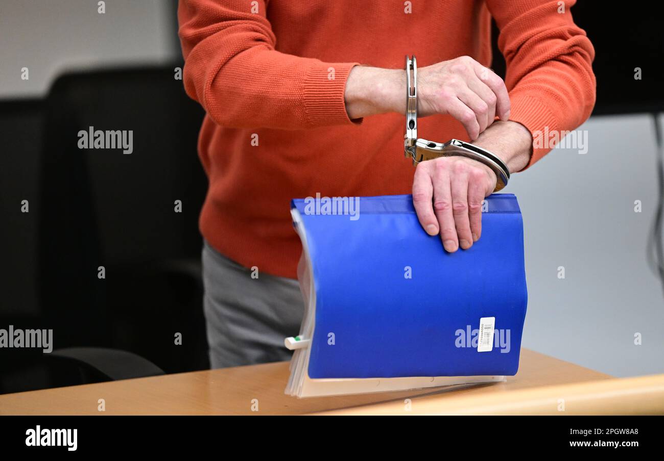 Stuttgart, Germany. 24th Mar, 2023. The defendant stands handcuffed in ...