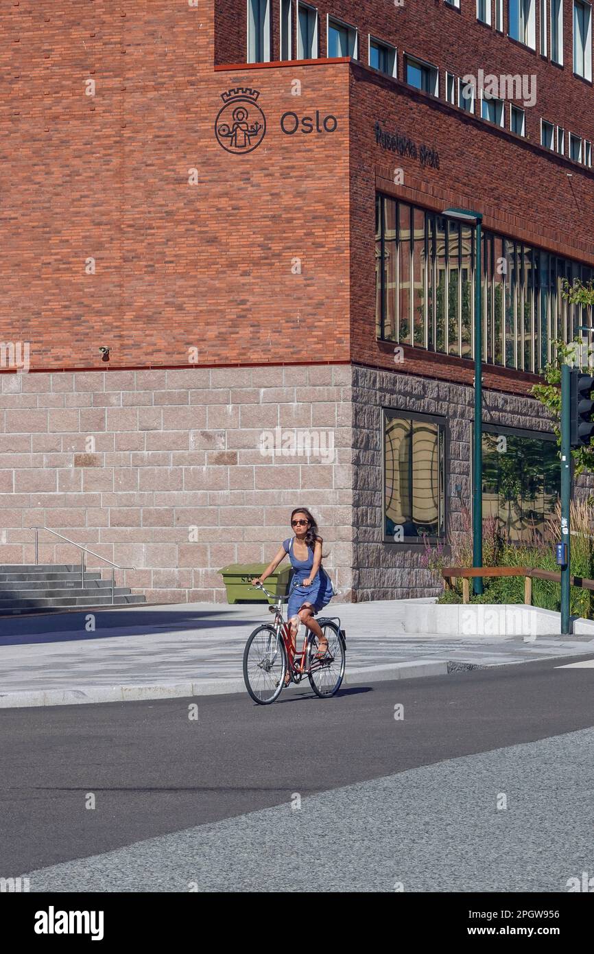 Norway, Oslo, A woman rides a bicycle in Oslo. Photo © Fabio Mazzarella ...