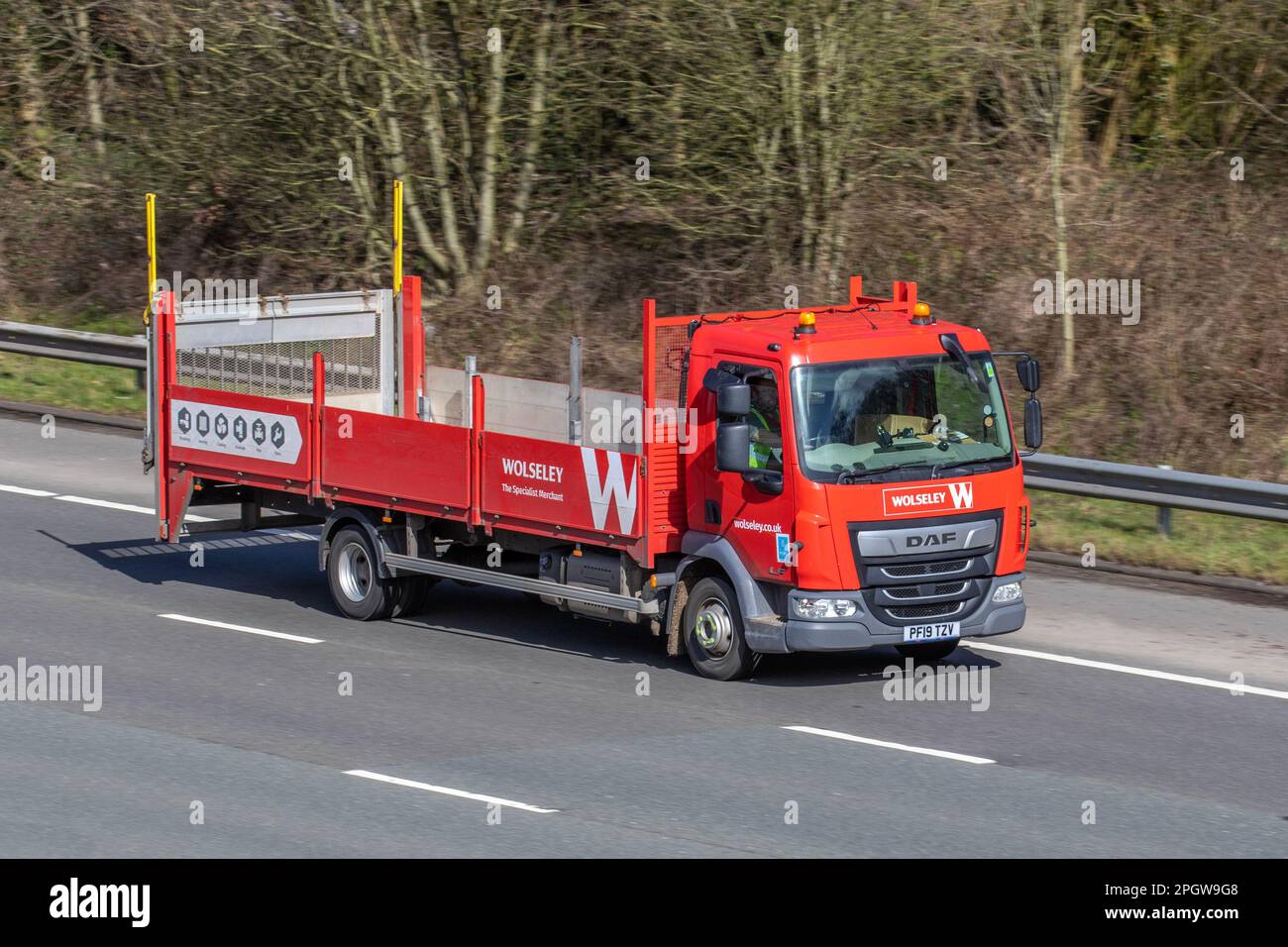 Red WOLSELEY drop sided DAF lorry travelling on the M61 motorway UK ...