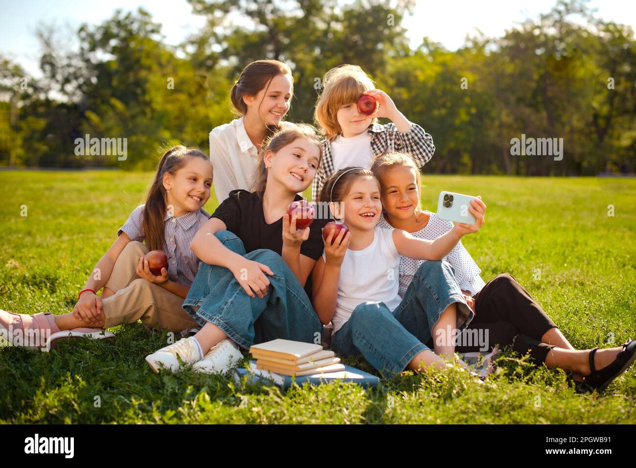 happy children take photo together on mobile phone in park in sunny day ...