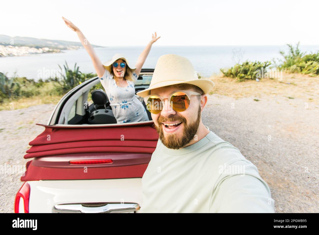 Happy beautiful couple in love taking a selfie portrait driving a ...