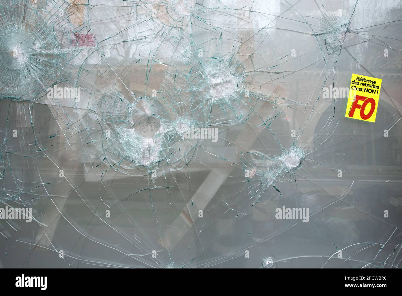 Paris, France. 23rd Mar, 2023. A broken shop window seen with a sticker ...