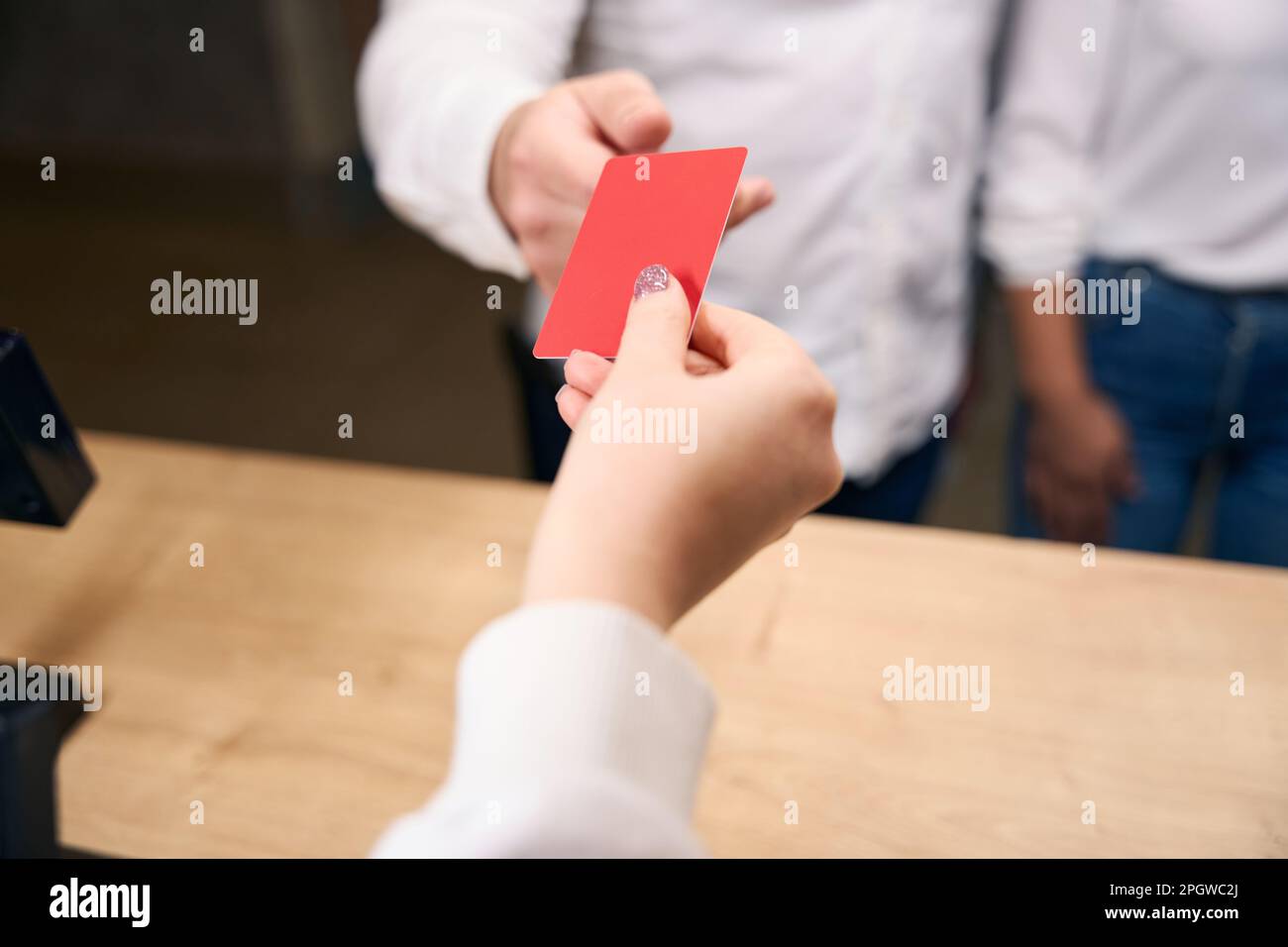 Front desk clerk handing keycard to hotel guests Stock Photo - Alamy