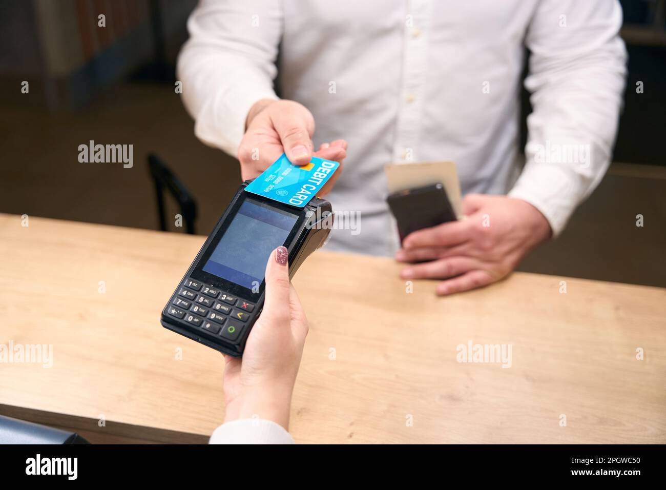 Guest paying for hotel room at reception desk Stock Photo - Alamy