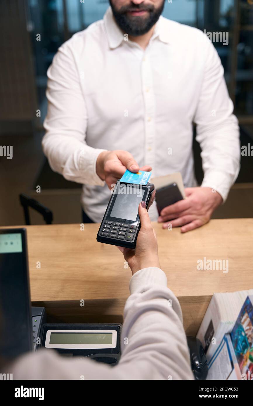 Tourist paying for his hotel room at reception desk Stock Photo - Alamy