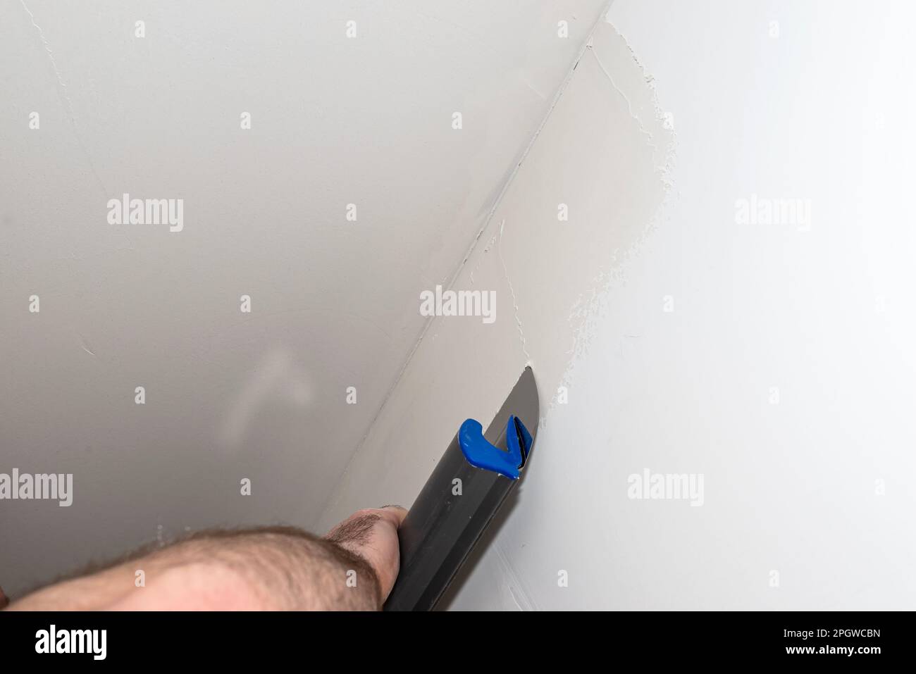 A man applies ready-made polymer plaster from a bucket using special ...