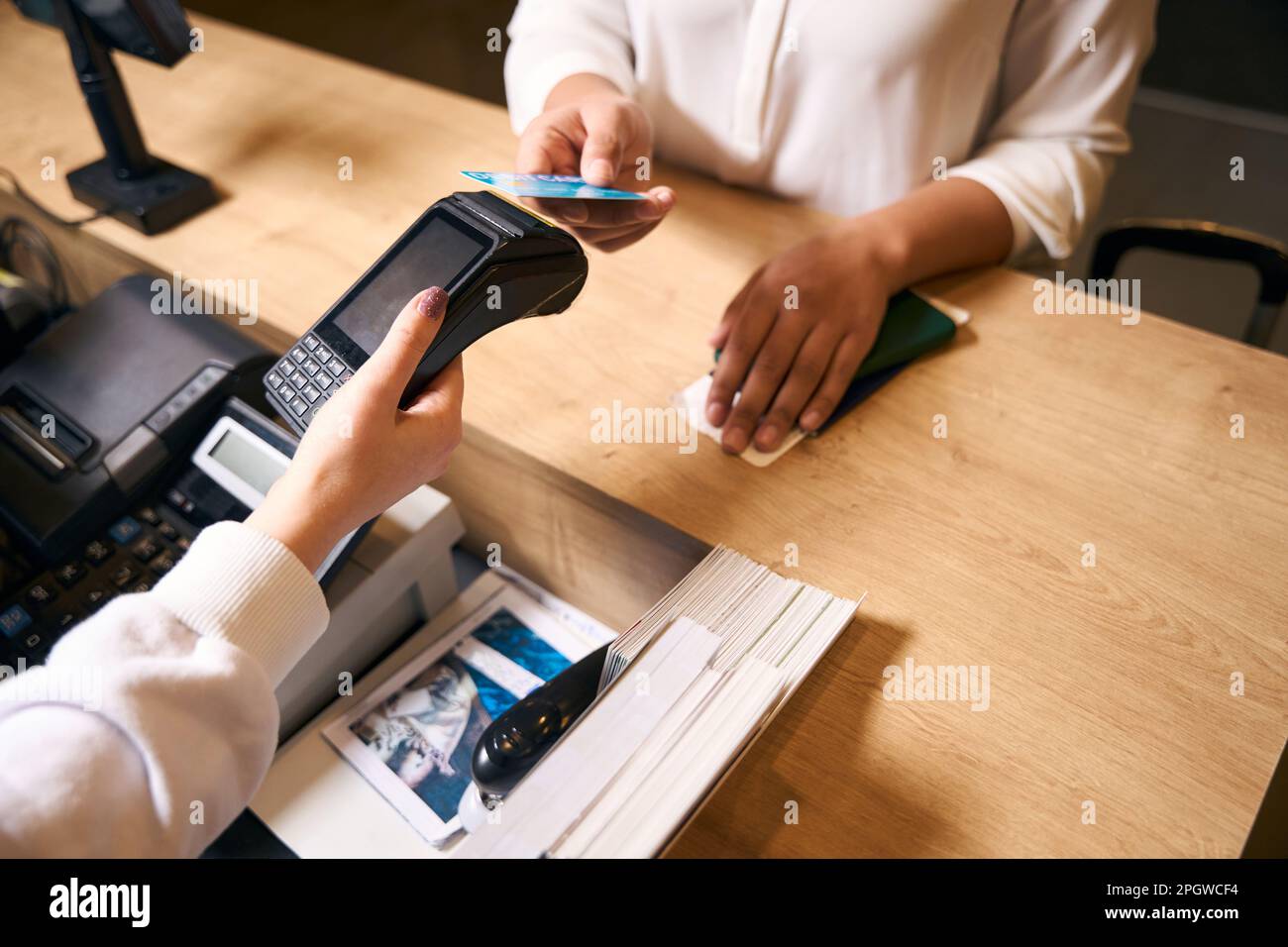 Guest paying for hotel room at reception desk Stock Photo - Alamy
