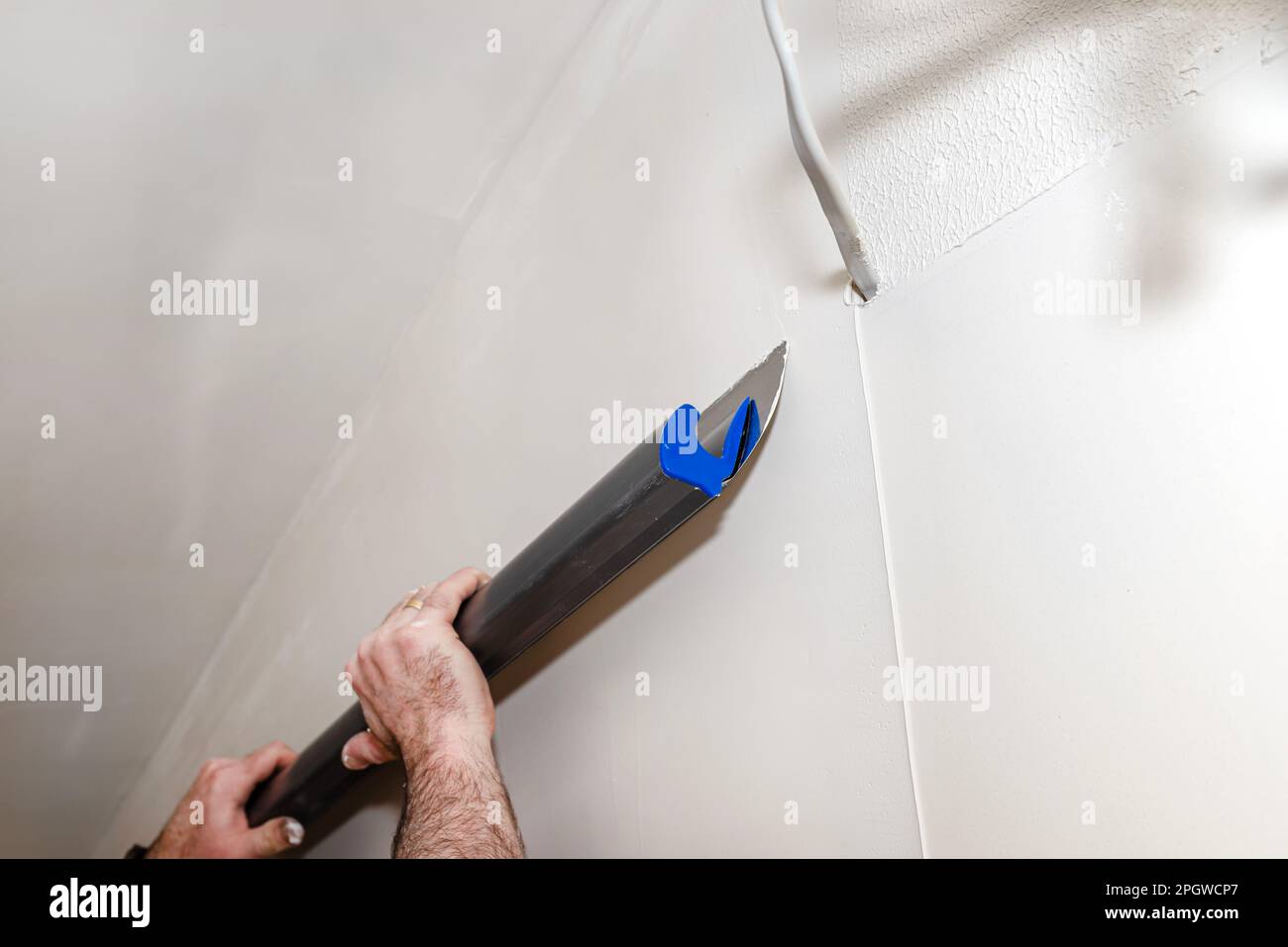 A man applies ready-made polymer plaster from a bucket using special ...