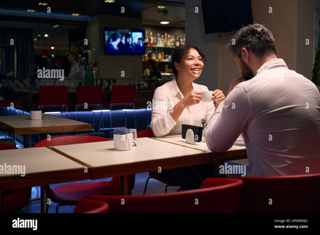 Joyous female and male whiling away time in coffee shop Stock Photo - Alamy