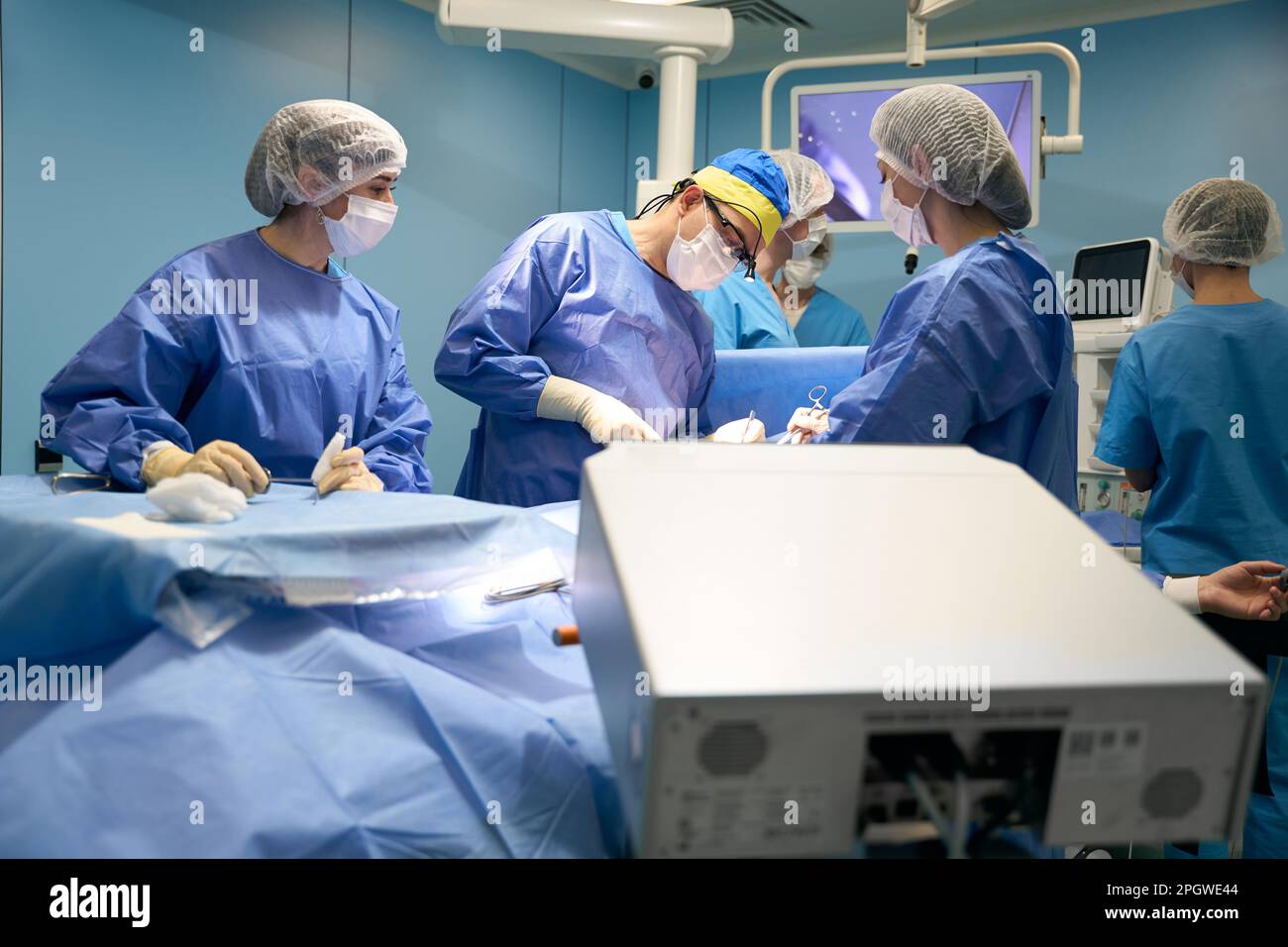 Surgeon operates on patient in sterile operating room, fellow ...