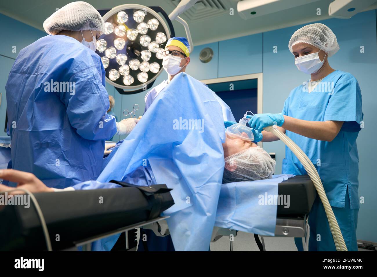 Woman anesthesiologist gives anesthesia to a patient through a mask ...