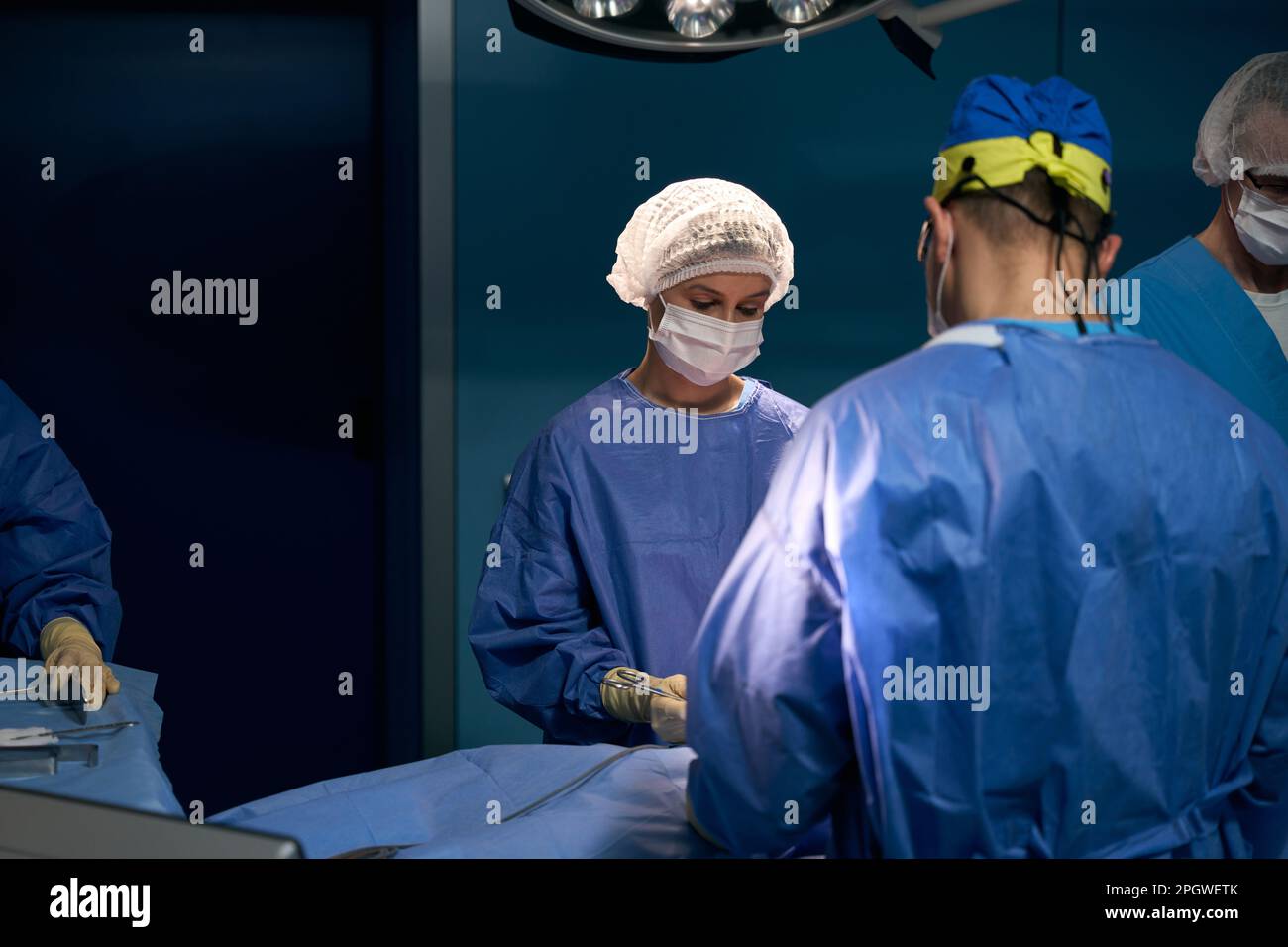 Assistants, anesthesiologist, operating room nurse work in operating ...