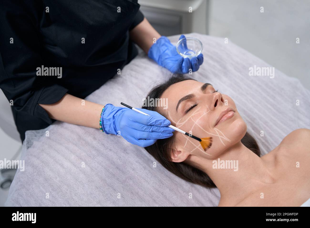 Nurse is preparing client face before procedure Stock Photo - Alamy