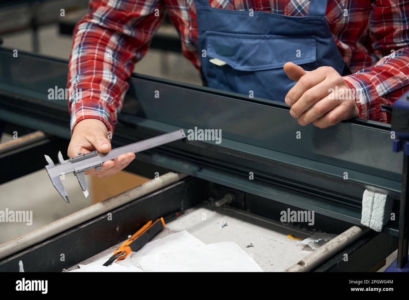 Professional man measuring metal details in factory Stock Photo - Alamy