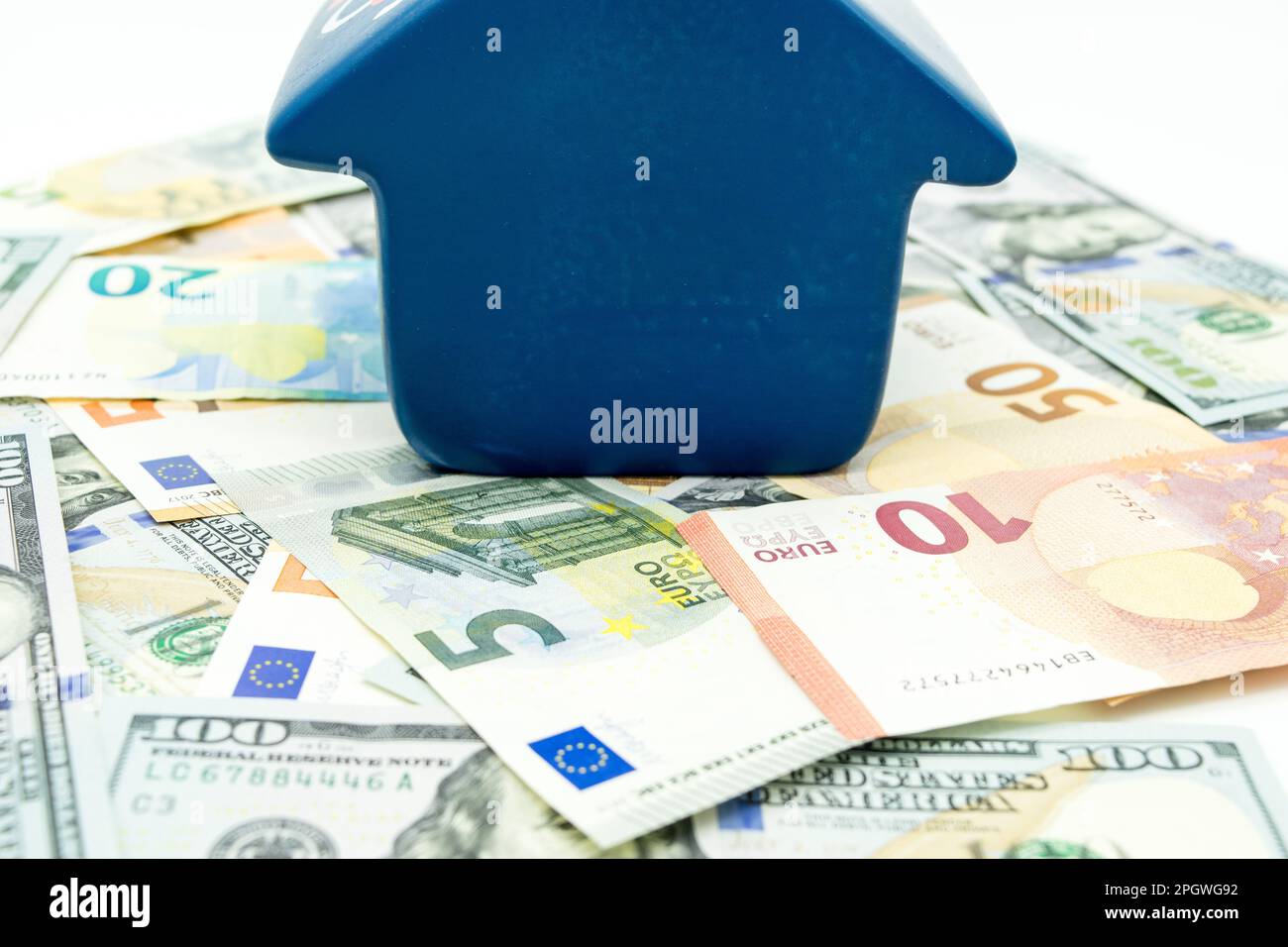 Small navy blue house standing on dollars, euro cash banknotes Stock ...