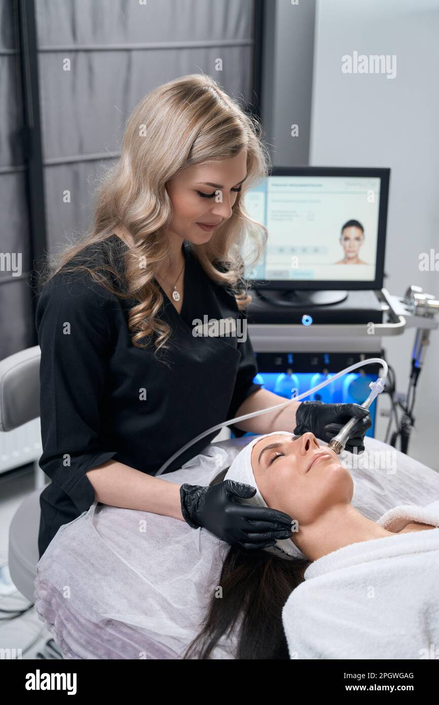 Professional beautician working in salon, doing skin resurfacing ...