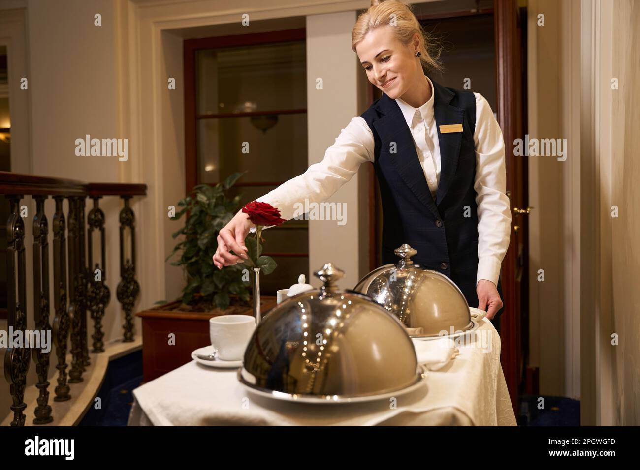 Caring waitress in uniform delivers food to a hotel room Stock Photo ...