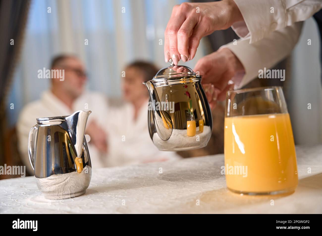 Hotel waitress serves morning coffee in room for couple in love Stock ...
