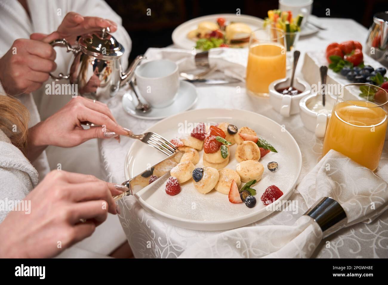 Woman is eating fruit salad with cutlery Stock Photo - Alamy