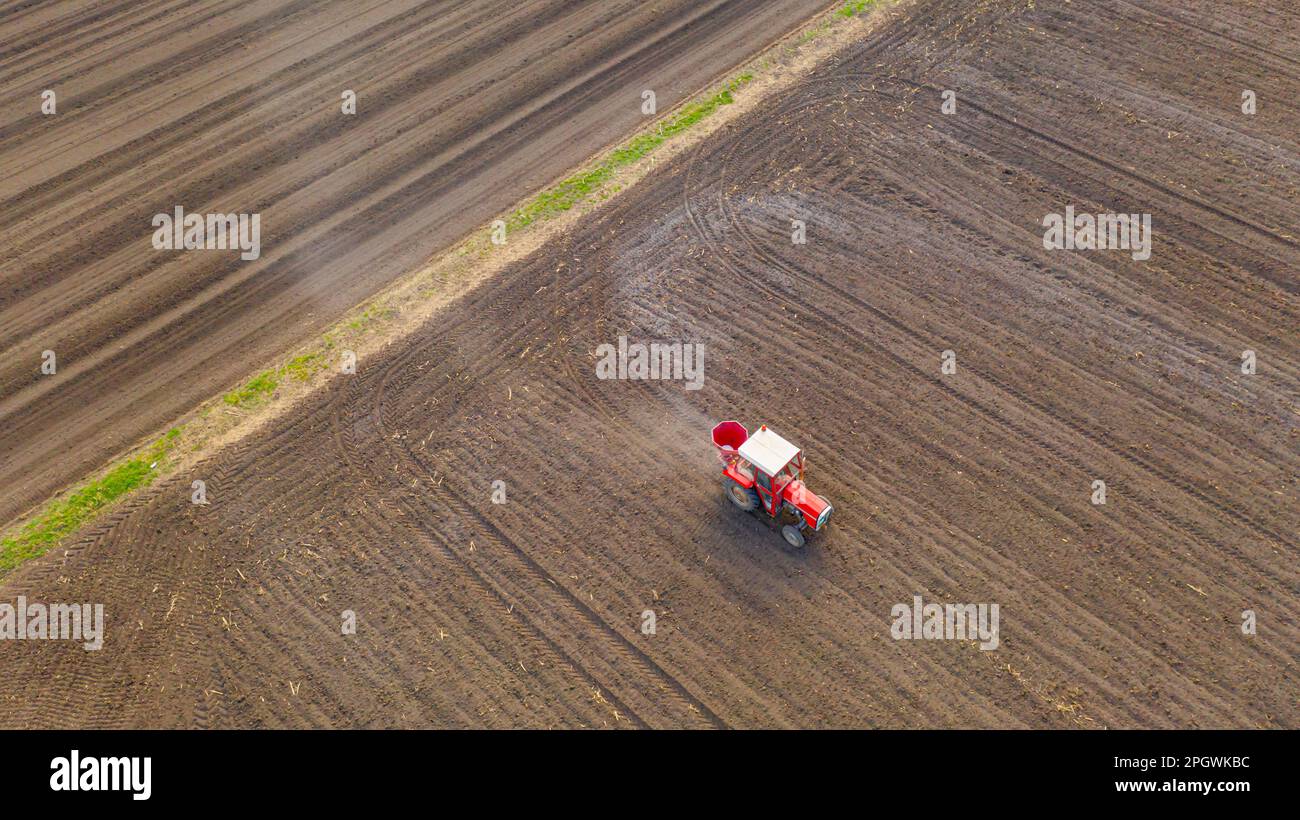 Above view on tractor as throws, fertilizing arable farmland for new ...