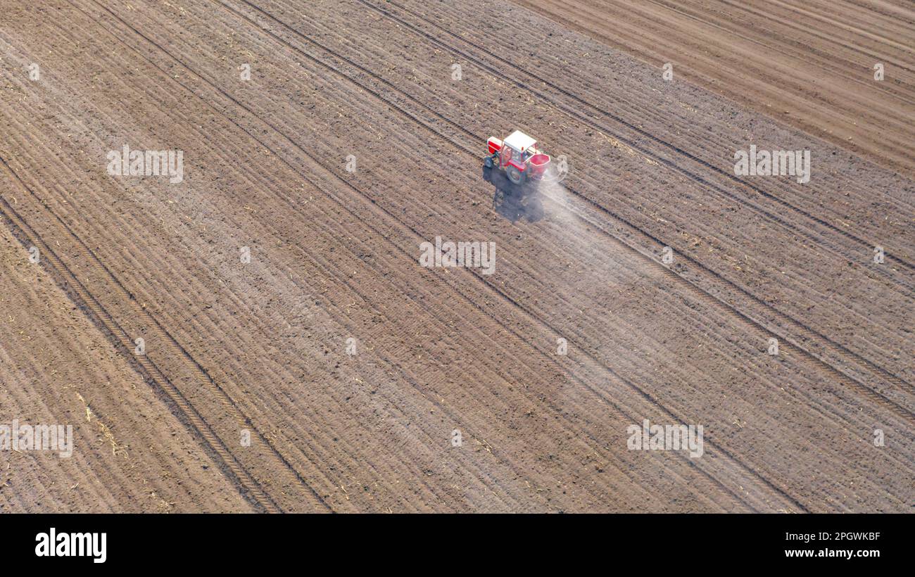 Above view on tractor as throws, fertilizing arable farmland for new ...