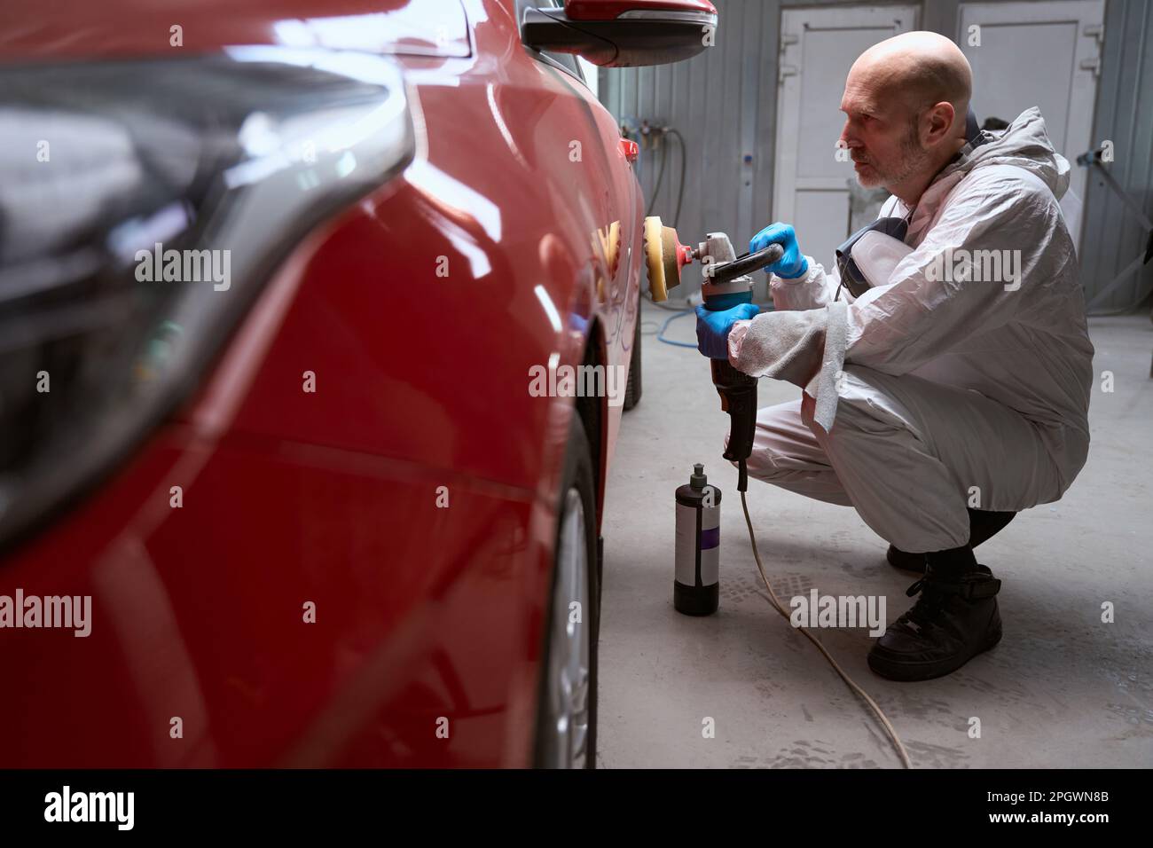 Car repairman at workplace works with body of red car Stock Photo - Alamy