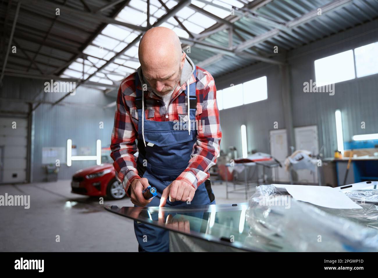 Male worker in a repair shop works with a windshield Stock Photo - Alamy