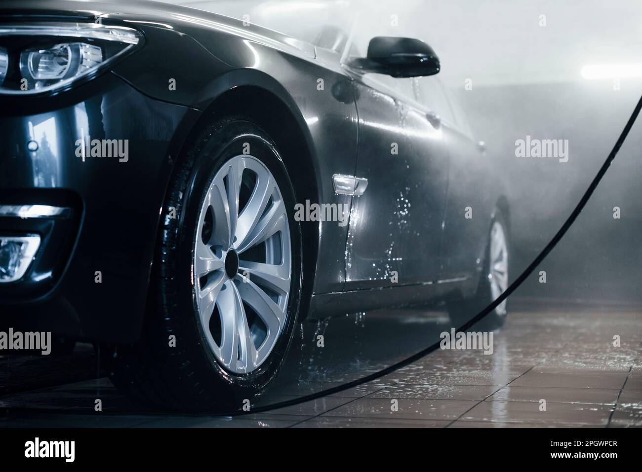 High pressured water. Modern black automobile get cleaned inside of car ...