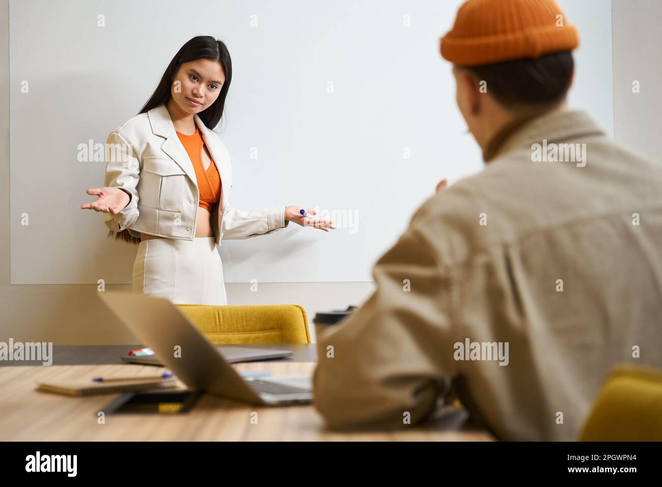 Female office worker giving presentation to colleague in meeting room ...