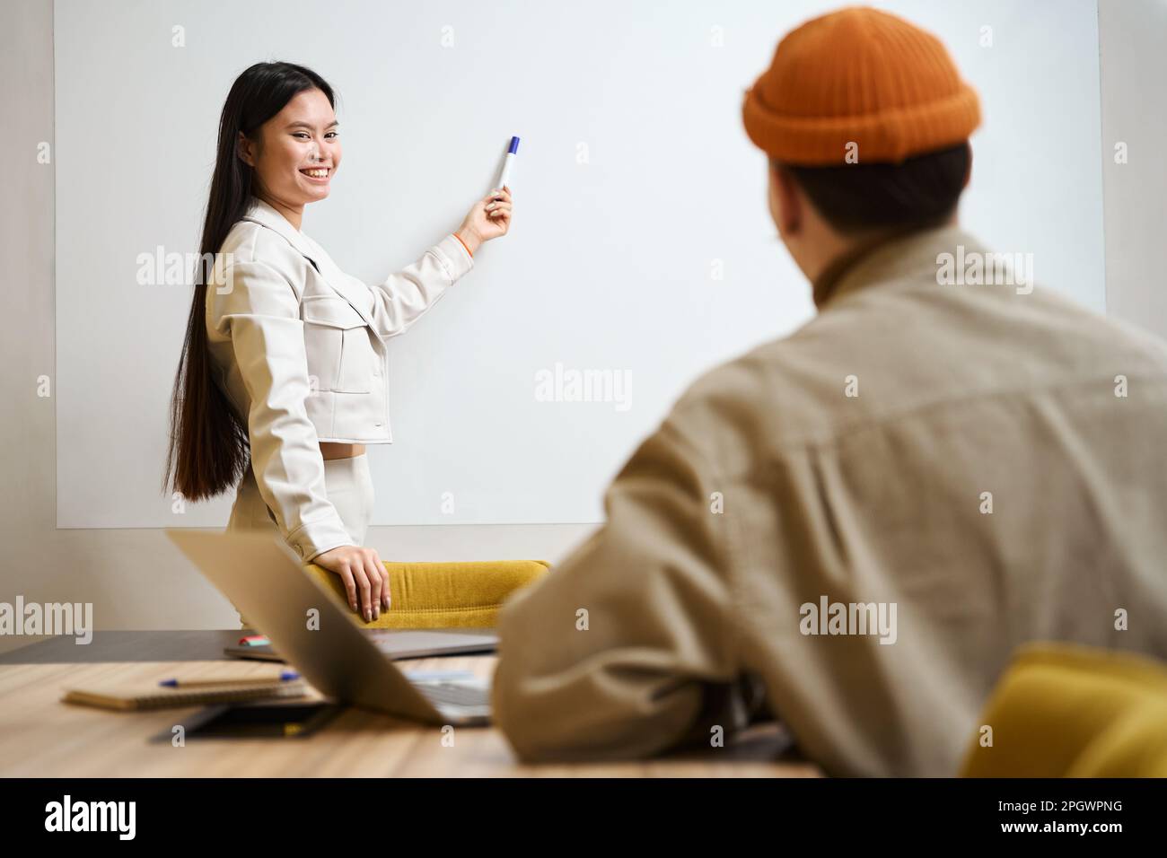 Joyous company employee giving presentation to colleague in meeting ...