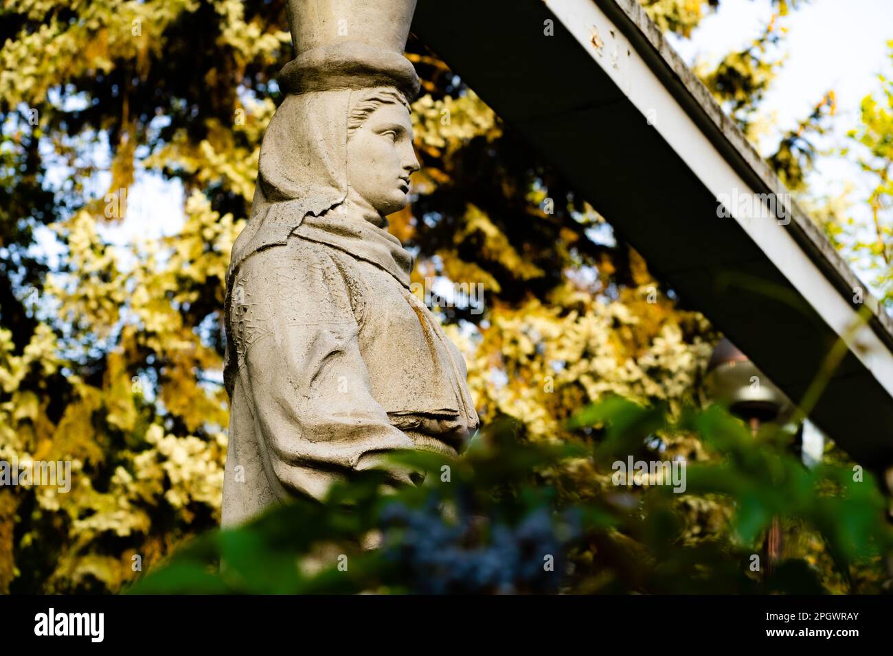 old statue in a park with foliage and rugged texture Stock Photo - Alamy