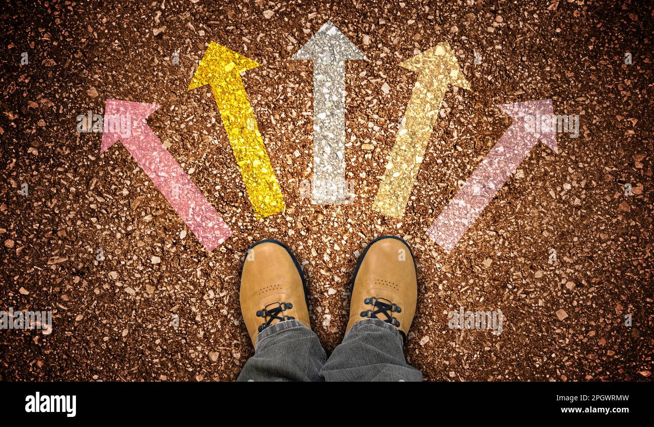 Yellow leather shoes and five colorful chalky arrows on ground ...