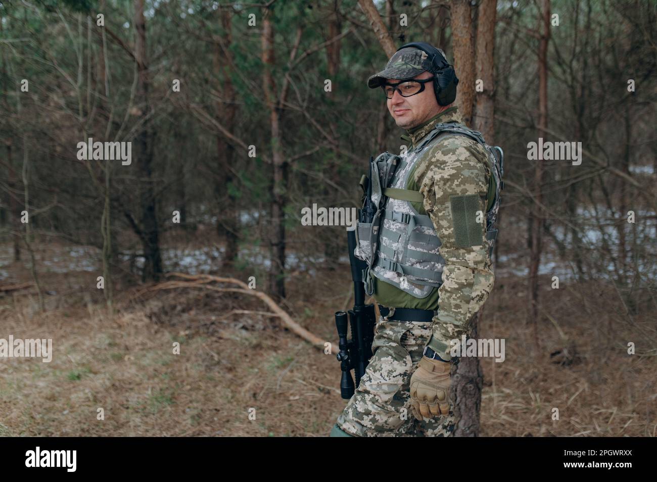 a soldier walks through the forest with a machine gun Stock Photo - Alamy