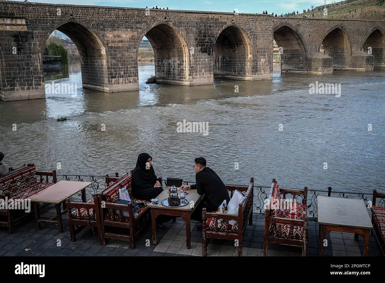 People seen sitting in a cafÈ next to the bridge. The Tigris Bridge ...
