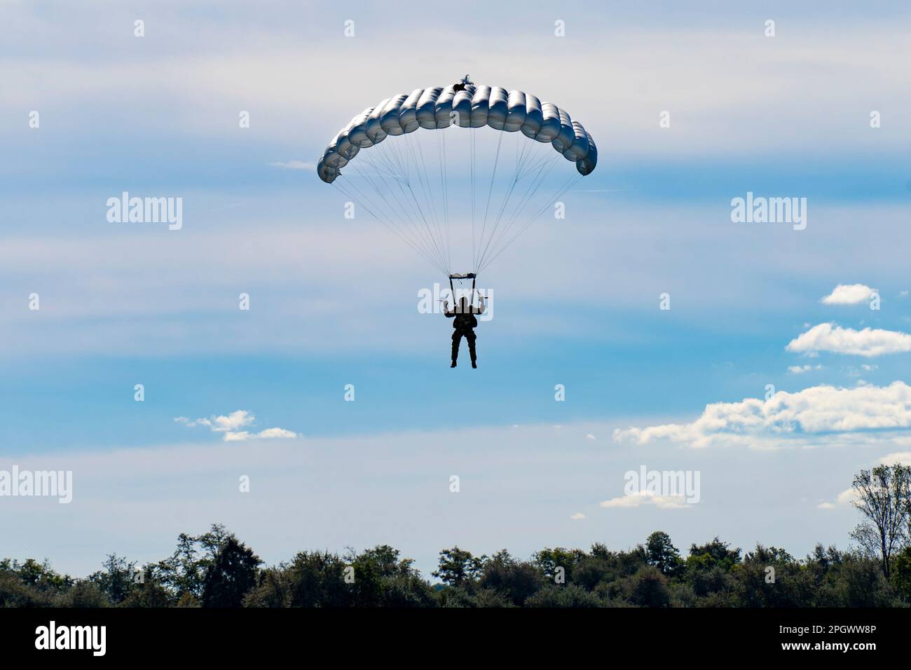 A parachutist descending with a white parachute Stock Photo - Alamy