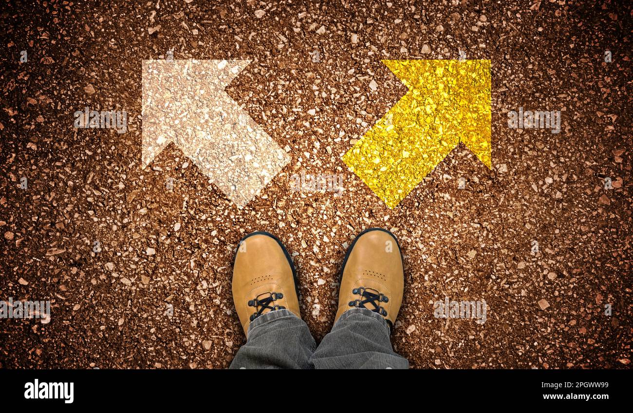 Yellow leather shoes and two right and left chalky arrows on ground ...