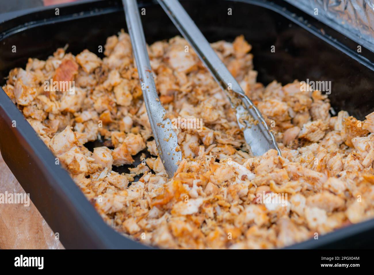 Cooked roasted chicken meat pieces in food container at local food ...