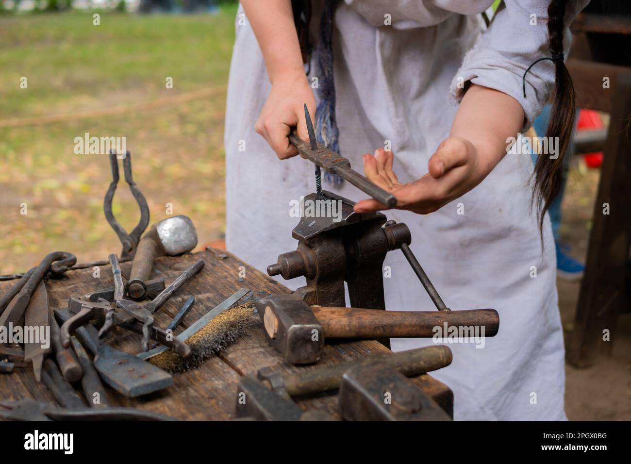Professional blacksmith woman working with metal on anvil - close up ...