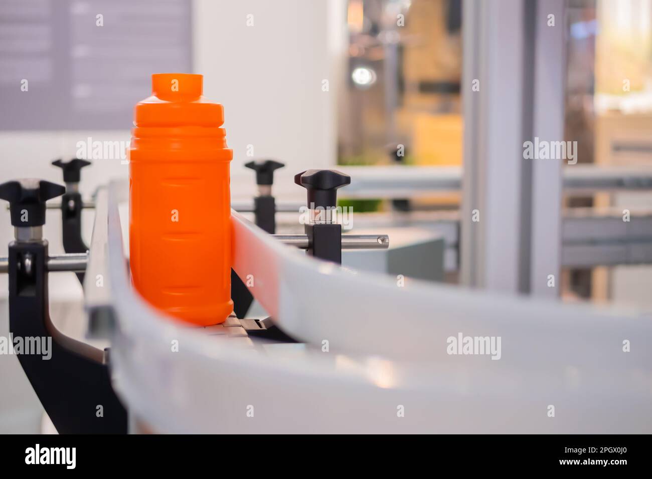 Empty orange plastic jerry can moving on conveyor belt at exhibition ...