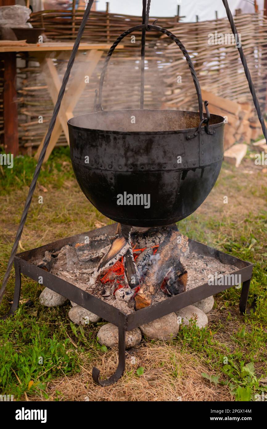 Preparing food in hanging pot over open fire - camping concept Stock ...